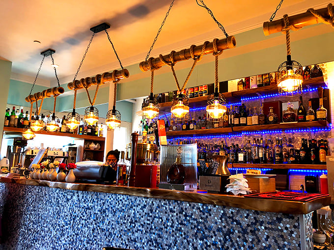 The bar's nautical-inspired lighting and blue glow create the perfect backdrop for pretending you're on the Amalfi Coast.