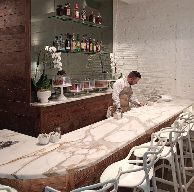 The marble bar gleams like a culinary altar, where libations are crafted with the same care as the restaurant's legendary breakfast offerings.