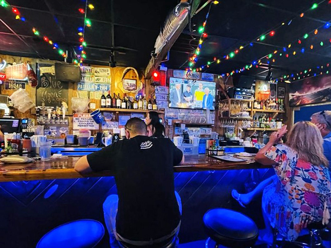 The bar glows with blue light and holiday cheer, where locals and tourists become friends over cold beers and fish tales.