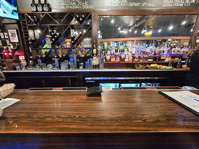 The wooden bar gleams under soft lighting, bottles standing at attention like soldiers guarding the gateway to a good time.