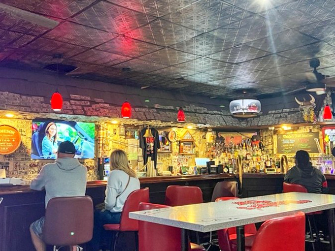 The bar area glows with promise, those red pendant lights casting a warm hue that says "pull up a stool and stay awhile."