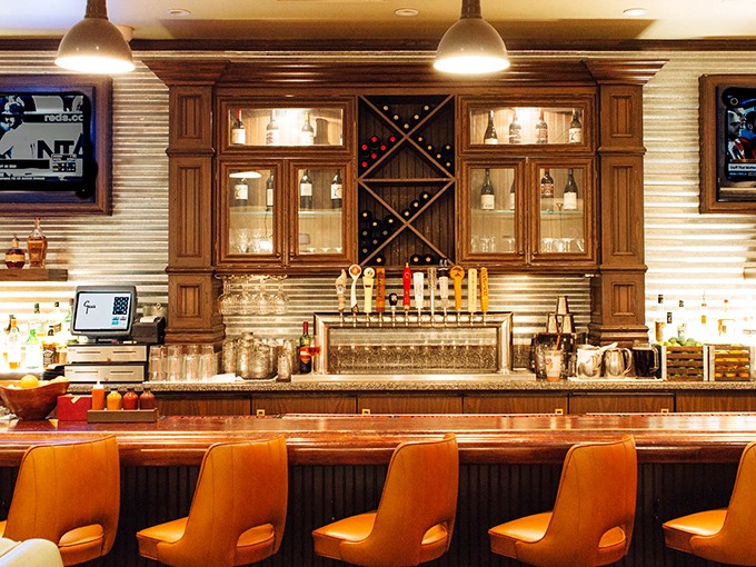 The bar isn't just serving drinks&mdash;it's crafting liquid companions for your barbecue journey. That bourbon wall is basically a shrine to good decisions.