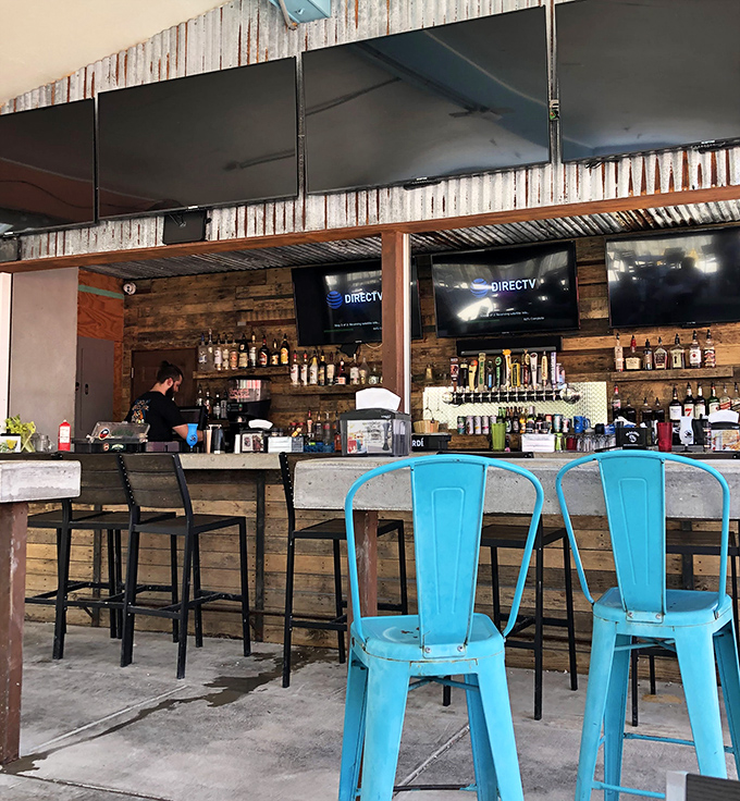 A bar built for stories&mdash;where weathered wood meets turquoise chairs, and bartenders mix drinks with the casual precision of people who understand vacation time is precious.