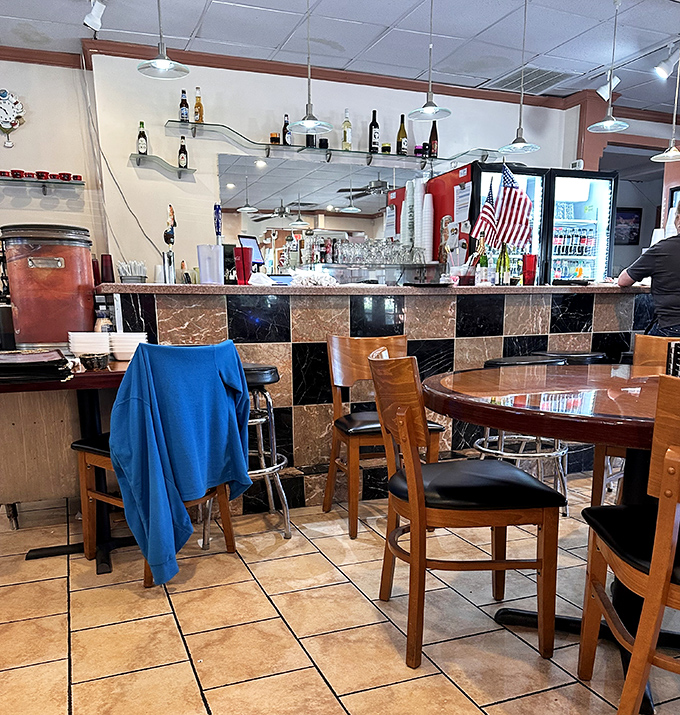 The checkered bar backdrop adds a touch of retro charm, while wooden chairs invite you to settle in and stay awhile&mdash;maybe for dessert?
