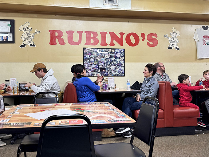 The wall proudly displaying "RUBINO'S" watches over families who've been coming here for decades, creating memories one square slice at a time.