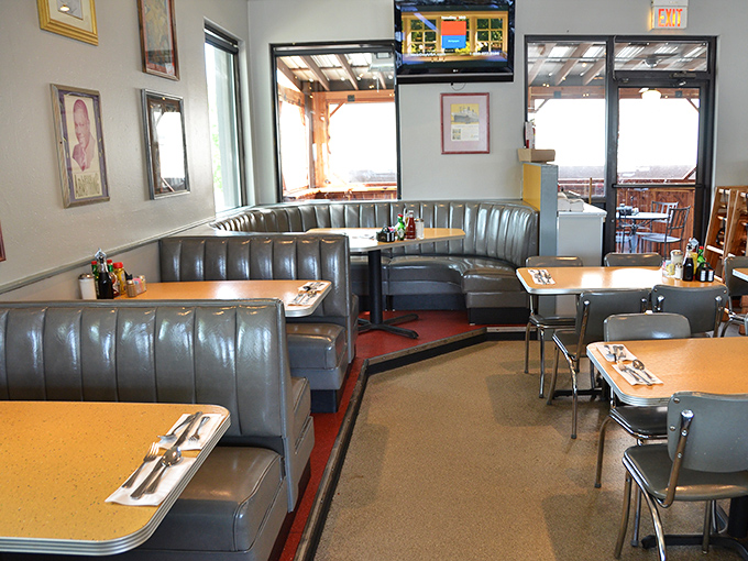 Booth seating arranged for maximum comfort and minimal eavesdropping. The warm wood tones and silver-blue upholstery create that classic deli atmosphere we all crave.