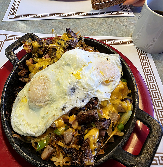 Breakfast skillet magic: where eggs, cheese, and potatoes meet in a cast iron paradise that sizzles with possibility.