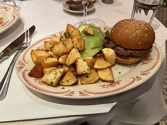 This isn't just a burger&mdash;it's architecture with a side of perfectly roasted potatoes. The sesame-studded bun practically winks at you from across the table.