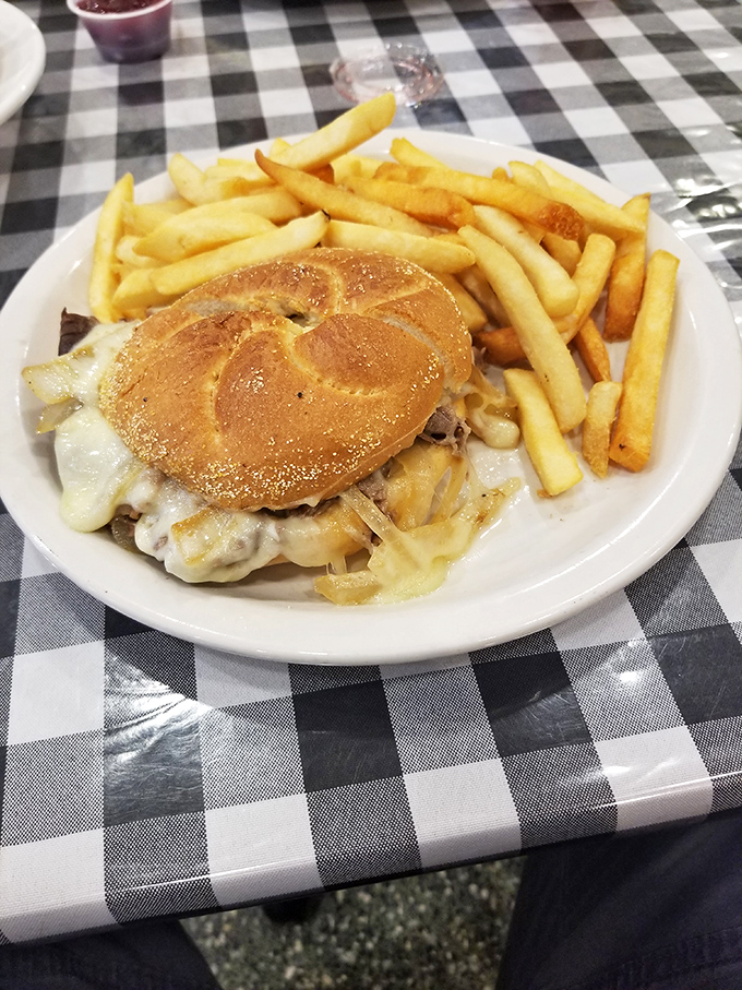 A proper diner patty melt on a checkered tablecloth&mdash;where melted cheese meets grilled onions in a union that would make any cardiologist nervous.