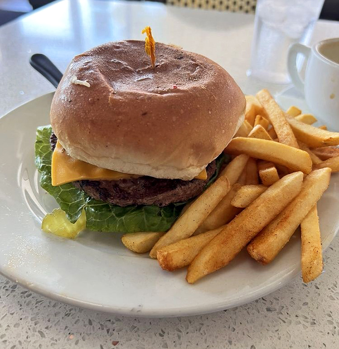 The classic American dream on a plate: a cheeseburger with lettuce, pickle, and fries standing by for support duty.