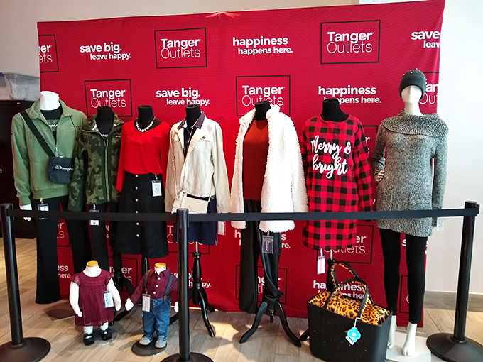 Mannequins sporting holiday looks that whisper, "Yes, you can pull this off at your family gathering." Tanger's signature red backdrop makes everything look festively discounted.