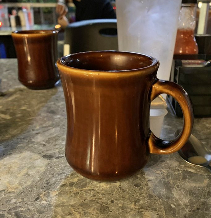 That brown ceramic mug isn't just holding coffee&mdash;it's cradling liquid motivation in the vessel that launched a thousand productive mornings.