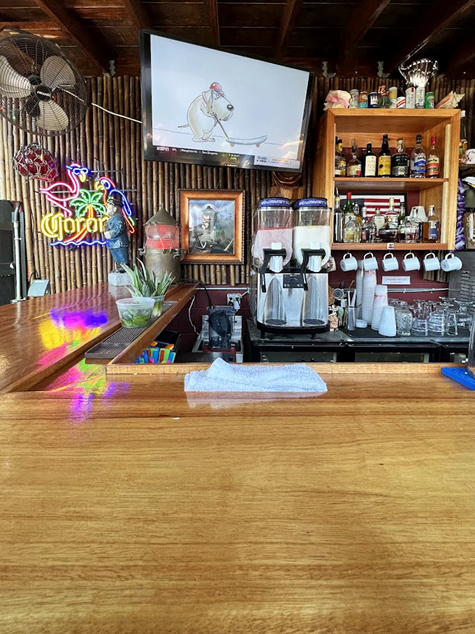 The bar area isn't just functional&mdash;it's a museum of island living with bamboo walls and neon signs that say "vacation" even on a Tuesday.