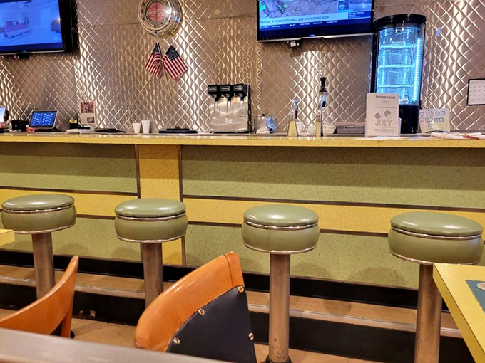 Classic diner counter seating where regulars perch for their morning coffee, complete with those swiveling stools that every kid secretly wants to spin on.
