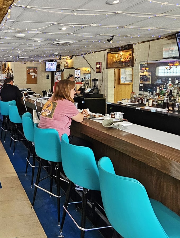 The bar where strangers become friends over shared pizza opinions. Those turquoise seats have heard decades of Chicago stories.