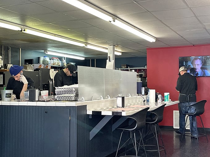 Behind this checkered counter, sandwich artistry unfolds with methodical precision – like watching Michelangelo, if his medium were mortadella instead of marble.
