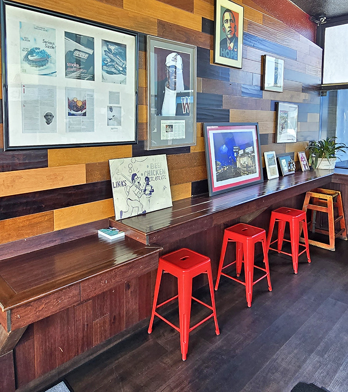 Wood-paneled walls adorned with memorabilia tell stories of community connections while those red stools await the next generation of BBQ enthusiasts.