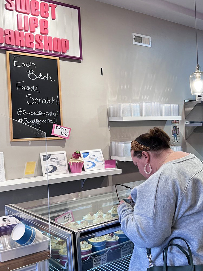 A customer contemplates life's sweetest decisions. In a world of uncertainty, at least choosing dessert brings pure joy.