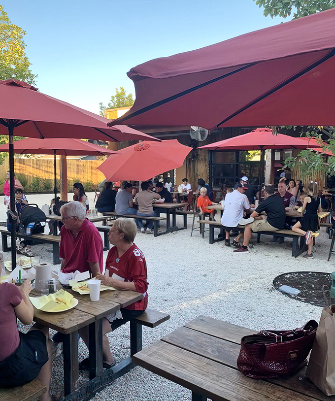 The outdoor patio: where San Antonians gather under burgundy umbrellas to worship at the altar of perfect burgers.