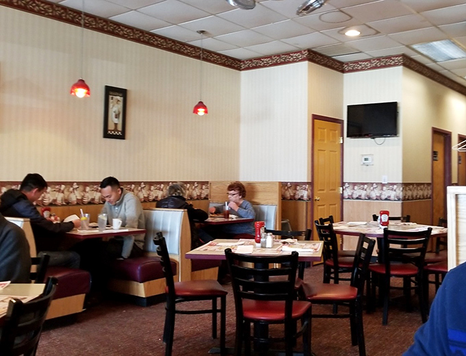 Red pendant lights cast a warm glow over diners who came for breakfast but stayed for the sense of community that no chain restaurant can replicate.