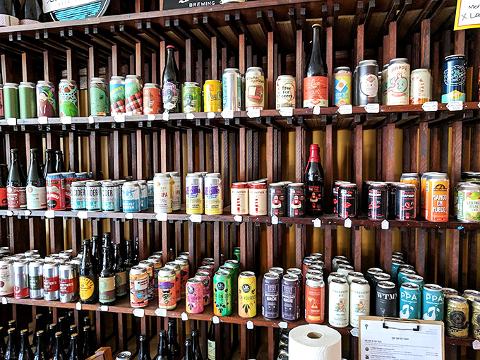 The craft beer selection rivals the barbecue in both variety and quality. This wall of cans represents a liquid tour of North Carolina's brewing prowess.