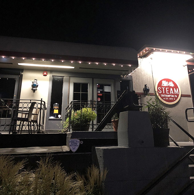 By night, Steam Pub glows with invitation, its illuminated sign a beacon for hungry travelers and locals alike seeking culinary comfort.