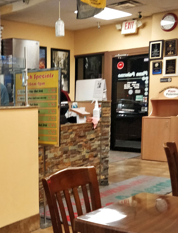 Inside Pizza Palermo, where the lunch specials board tempts you to become a regular. The stone accent wall adds a touch of character.