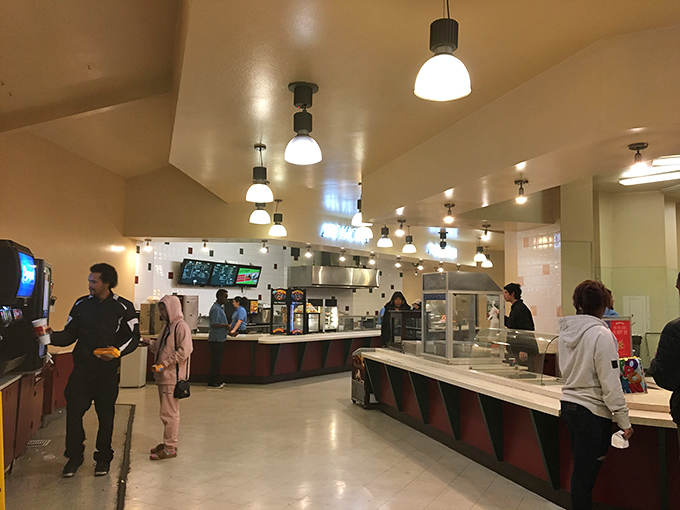 The concession counter buzzes with pre-show energy as moviegoers stock up on essential cinema fuel before returning to their automotive theaters.