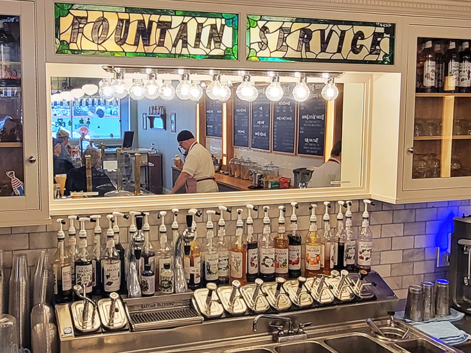 That stained glass "Fountain Service" sign isn't just decoration&mdash;it's a promise of fizzy, frothy delights crafted with the precision of a Swiss watchmaker.