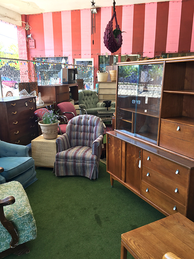 Mid-century furniture arranged under candy-striped awnings creates a living room time capsule. Don Draper would feel right at home here.