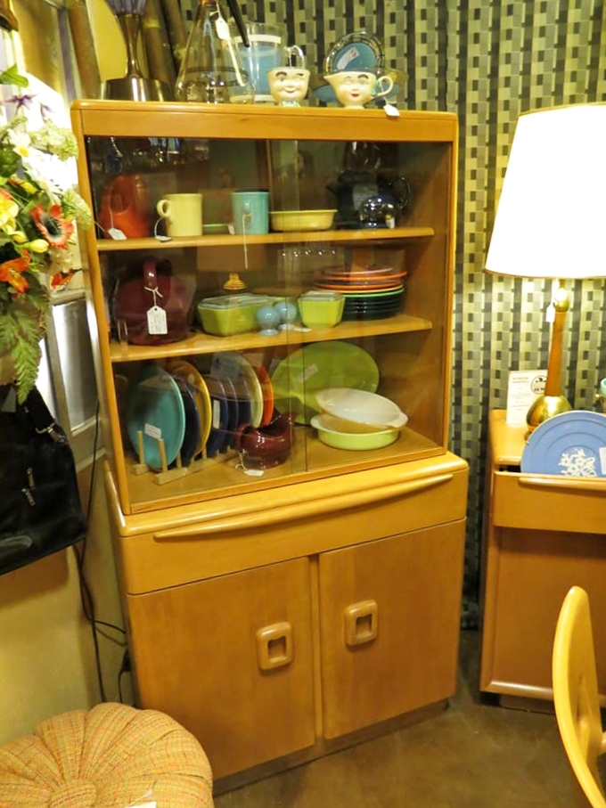 Mid-century cabinet displaying colorful Fiestaware and glassware—the kind of pieces that make ordinary Tuesday dinners feel special.