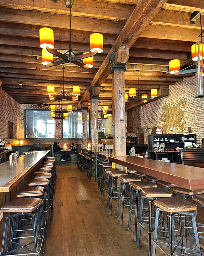 Morning light streams through windows illuminating wooden beams that have witnessed centuries of Baltimore history, now hosting Thai culinary magic.