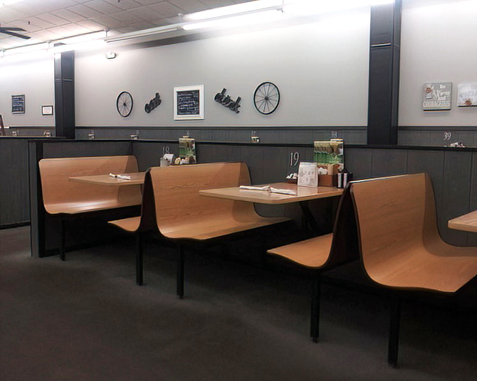 Booths designed for lingering conversations and second cups of coffee. Notice the bicycle wheels on the wall &ndash; quirky touches that feel just right.