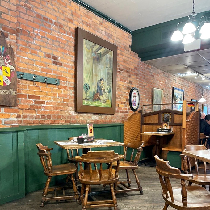 Cozy corner seating where strangers become friends over shared plates of spaetzle. Those wooden chairs have supported generations of satisfied diners.