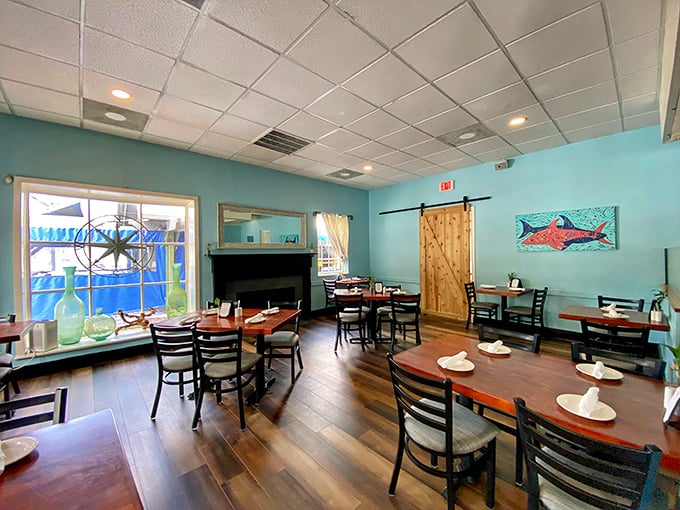 Seafood-inspired art adorns walls the color of a calm sea, creating a dining room that feels like it's giving you a maritime hug.