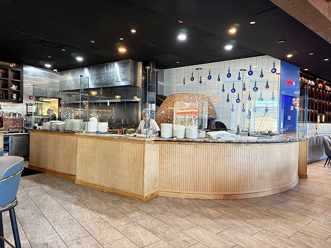 The semi-open kitchen reveals the heart of Dolan's operation, where traditional bread emerges from the dome-shaped tandoor oven in perfect rounds.