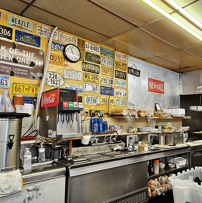 Where breakfast magic happens. The kitchen wall's license plate collection suggests these cooks have traveled far to perfect their hash brown technique.