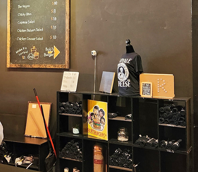 The merch corner proves people love these burgers enough to wear the evidence. That t-shirt is basically a wearable trophy saying "Yes, I've been there."