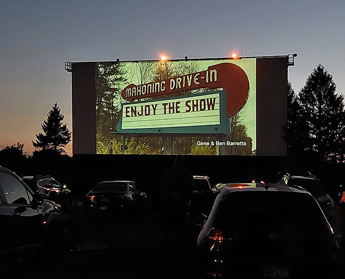 As darkness falls, the Mahoning's screen illuminates with its signature pre-show, casting a glow across rows of expectant faces.