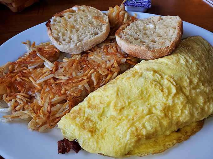 An omelet that's achieved perfect fluffiness, alongside hash browns crisped to that magical point between golden and caramelized.