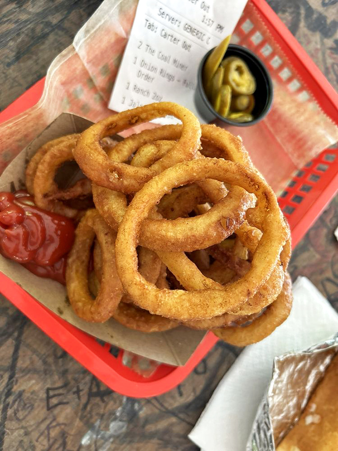 Golden onion rings stacked like delicious jewelry. Crispy on the outside, tender within&mdash;the way all good things should be.