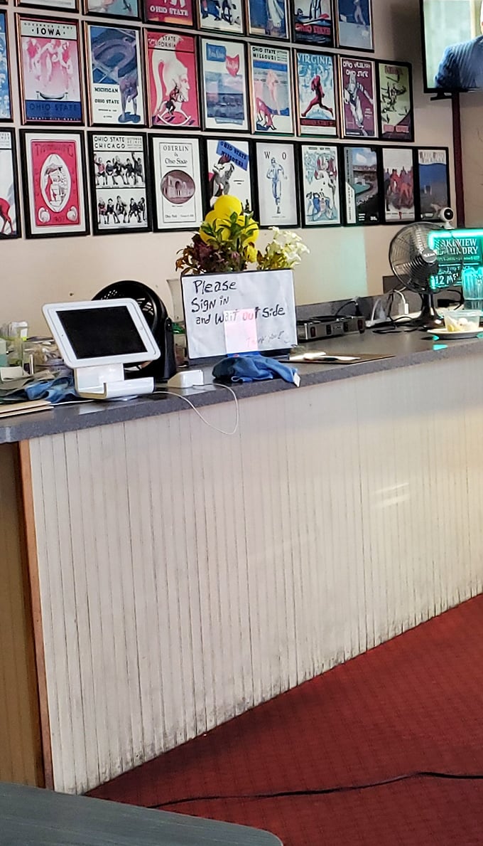 Ohio State memorabilia watches over the counter like breakfast guardian angels. The "please sign in" note adds that perfect neighborhood touch.