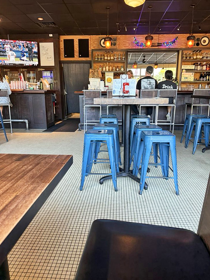 Blue stools invite you to belly up to the bar. The mosaic tile floor adds a touch of vintage charm to this modern burger haven.