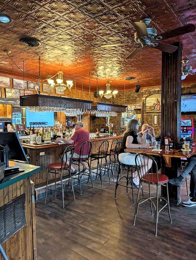 The bar area features ornate tin ceilings, warm wood tones, and comfortable seating where regulars and newcomers alike find common ground.