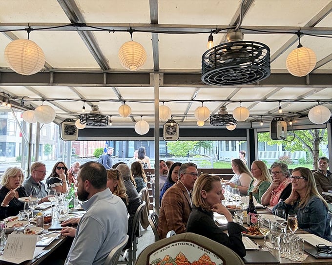 The covered patio offers front-row seats to Indianapolis life, with paper lanterns creating that "I could sit here all evening" ambiance.