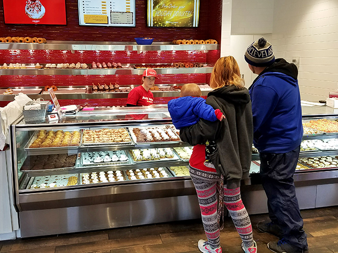 The family donut selection process&mdash;a delicate negotiation where everyone wins, especially the kid eyeing that chocolate-frosted beauty.