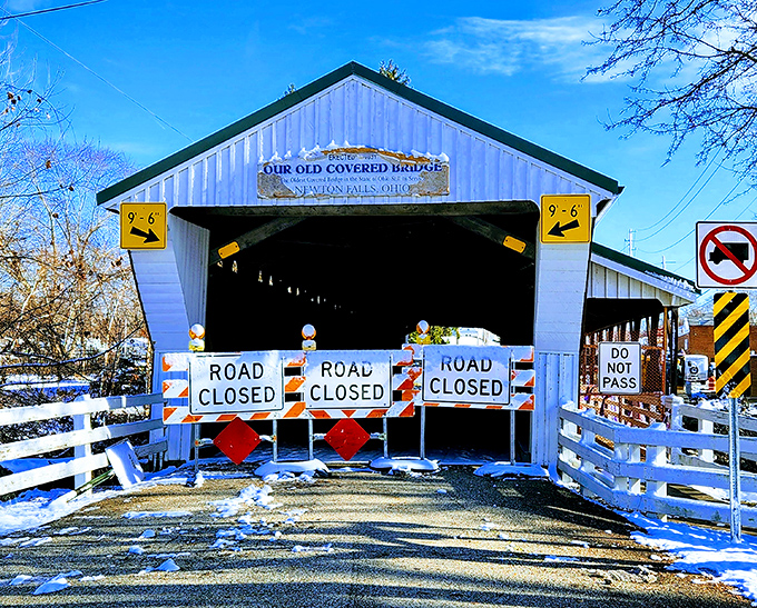 Winter transforms the bridge into a snow-capped postcard, the "Road Closed" signs adding that perfect touch of bureaucratic charm to nature's artwork.
