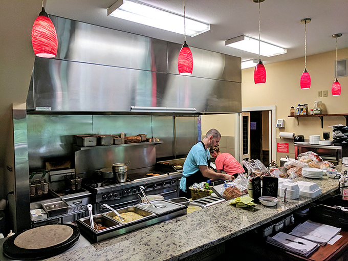 Where the magic happens! Those red pendant lights hang like culinary beacons over a kitchen that knows its way around a breakfast skillet.