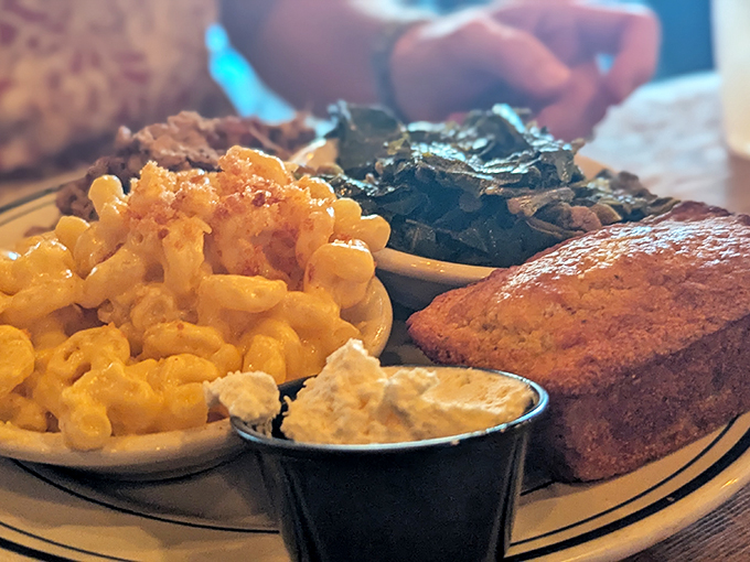 A plate that understands the importance of balance—golden mac and cheese, vibrant collard greens, and cornbread that's begging for a swipe of butter.