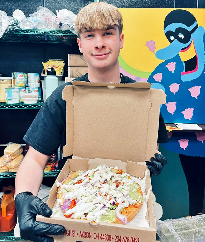 Behind every great pizza is someone who knows exactly what they're doing. That smile says, "Trust me, this is going to be the highlight of your week."